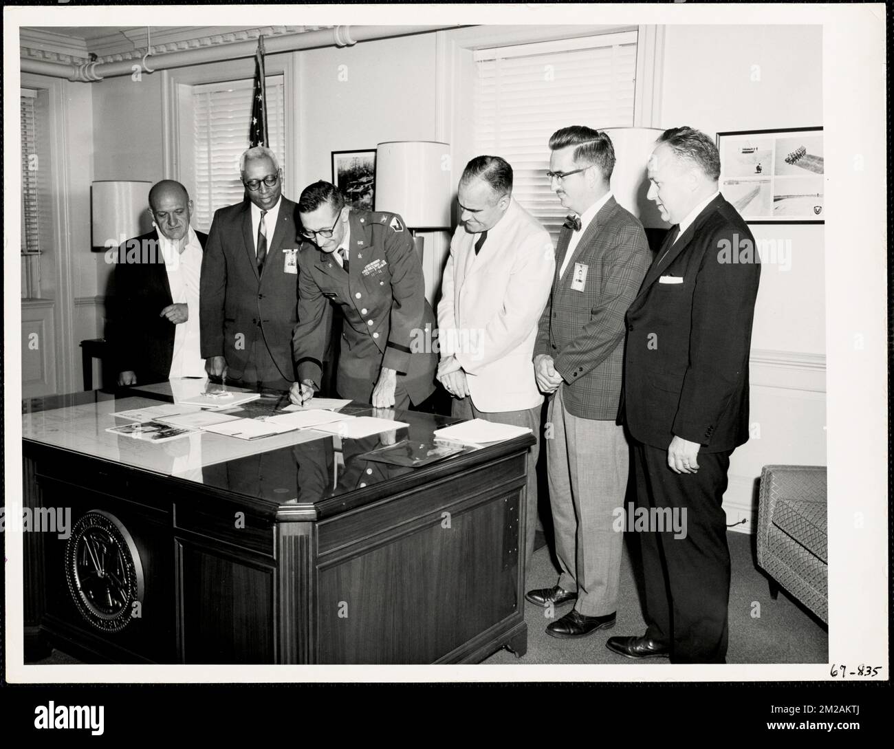 Col. Kellogg signing document , Ordnance industry, Armories, Gates ...