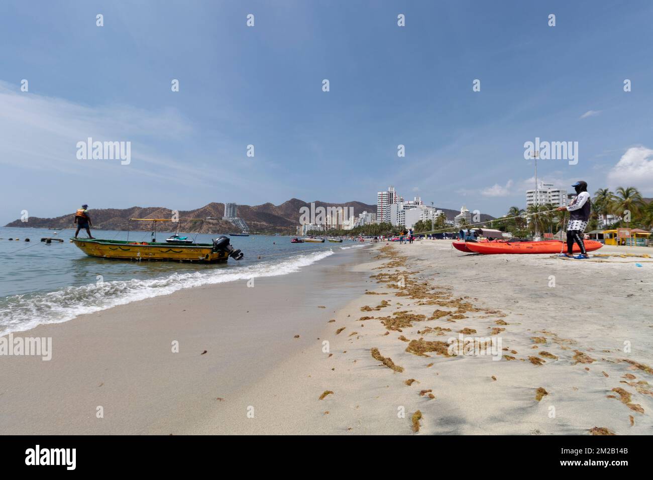 Two tourist guides holding a boat in rodadero beach in sunny day Stock ...