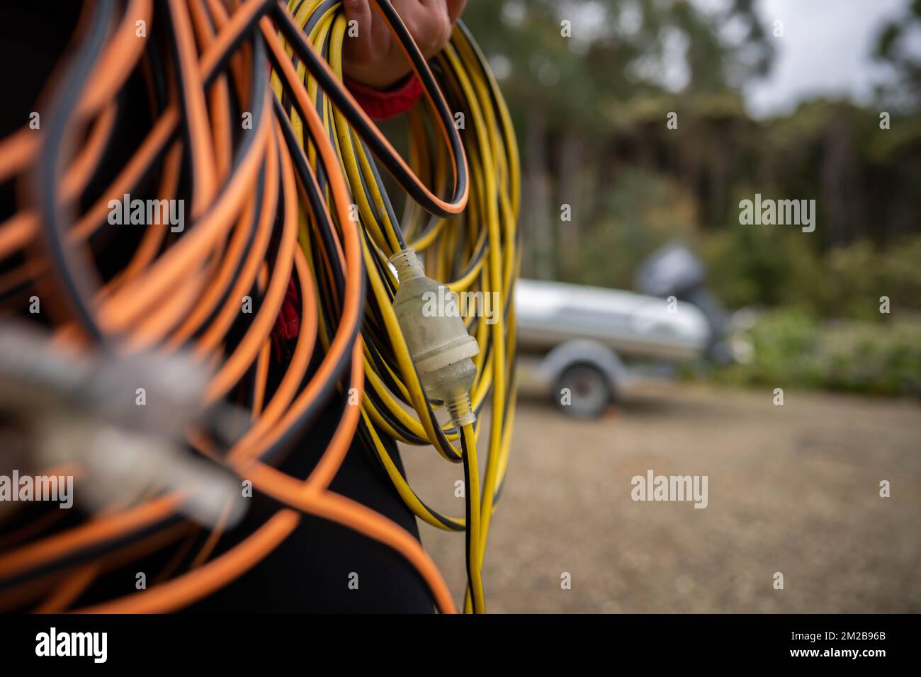 power lead on a building site, electrician with a power cable outside ...