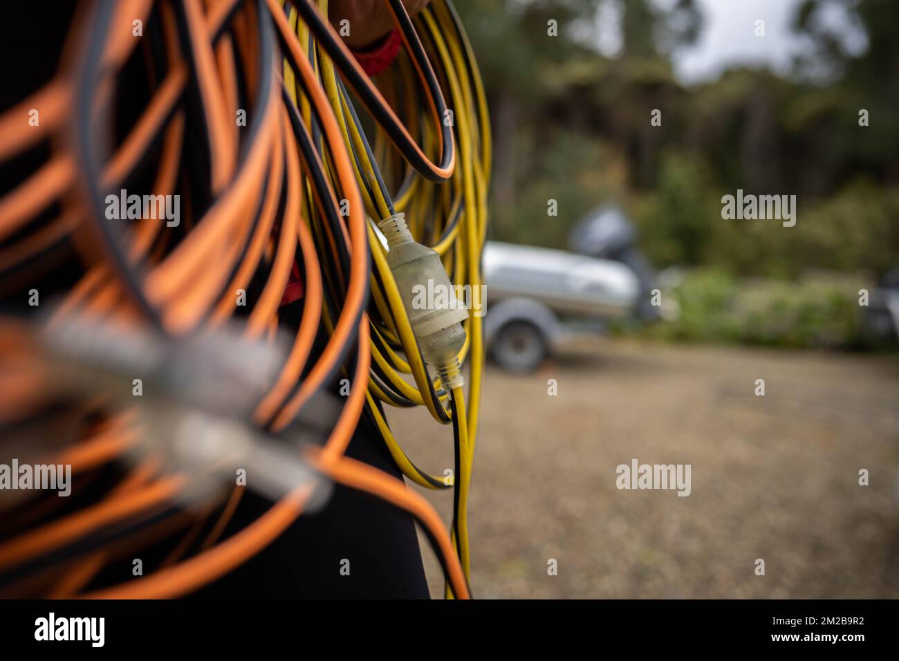 extension cord wrapped up on the ground. extension lead, power lead on ...