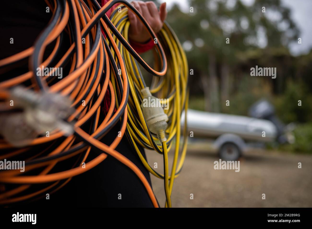 extension cord wrapped up on the ground. extension lead, power lead on ...