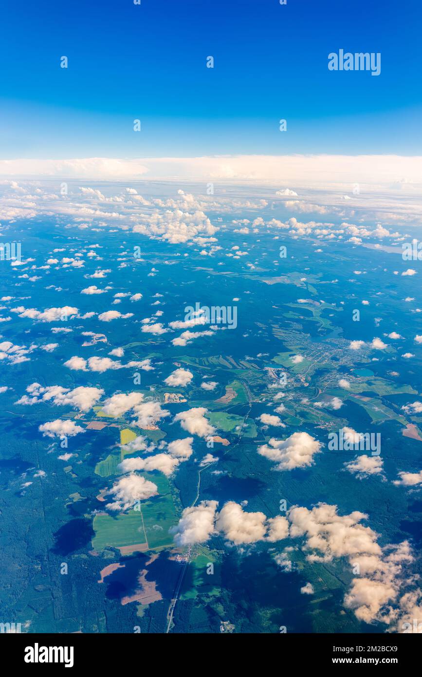 Aerial view from airplane window above green ground. View from the ...