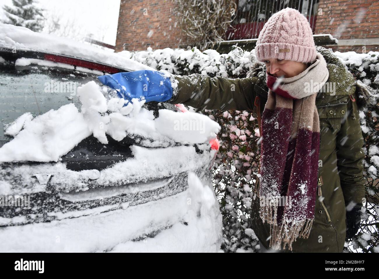 Illustration picture shows A woman clears snow from the rear window of her car as cold ...