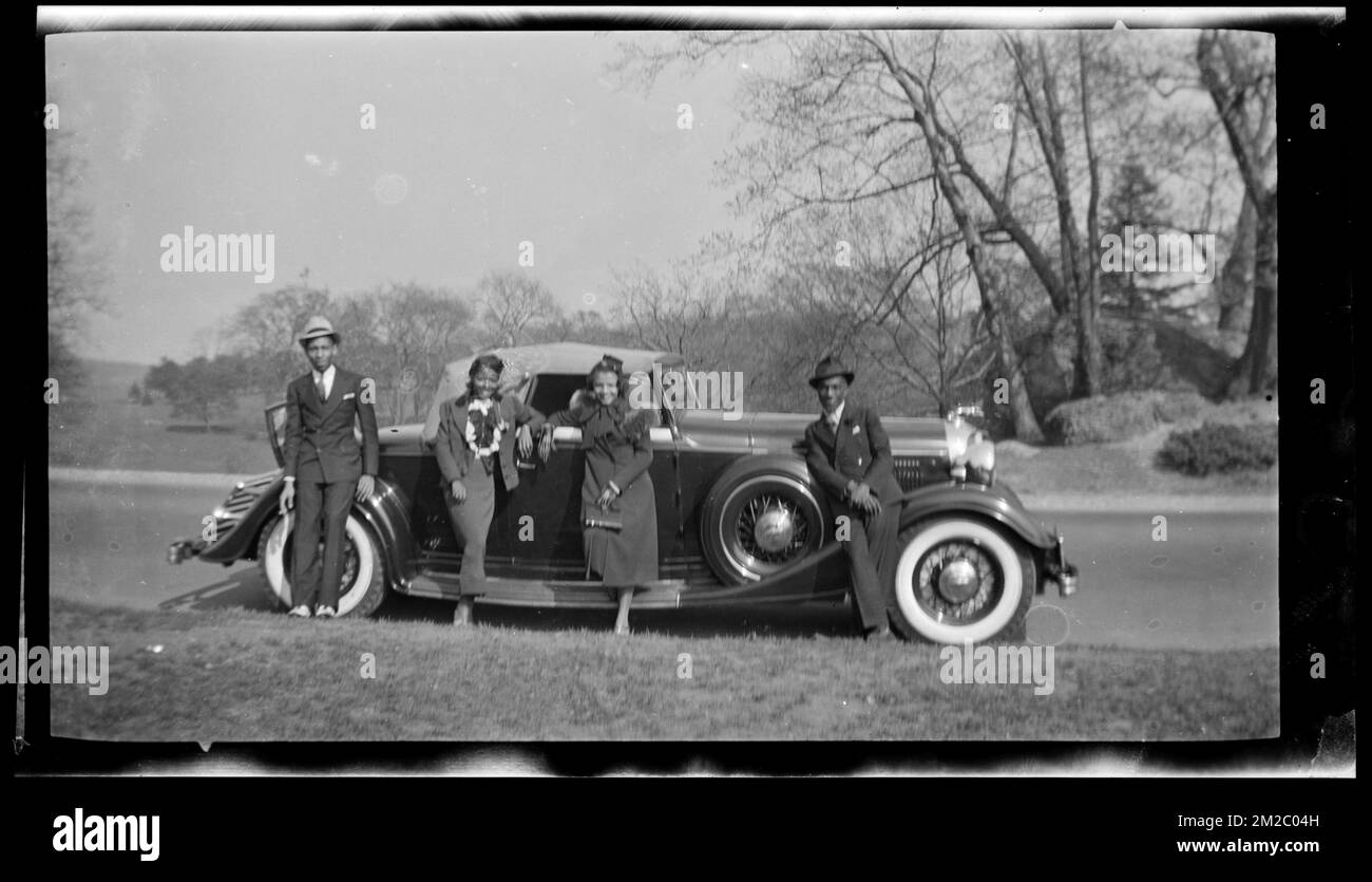 Constance Miller, a woman and two men pose in front of a car ...