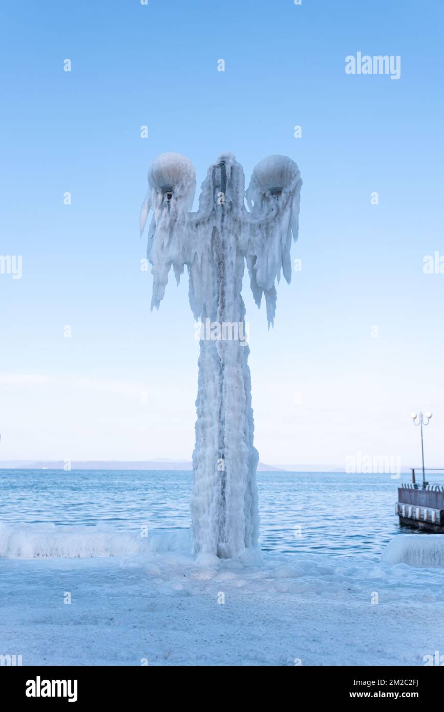 Frozen city after freezing rain. Vladivostok. The street lamp is frozen ...