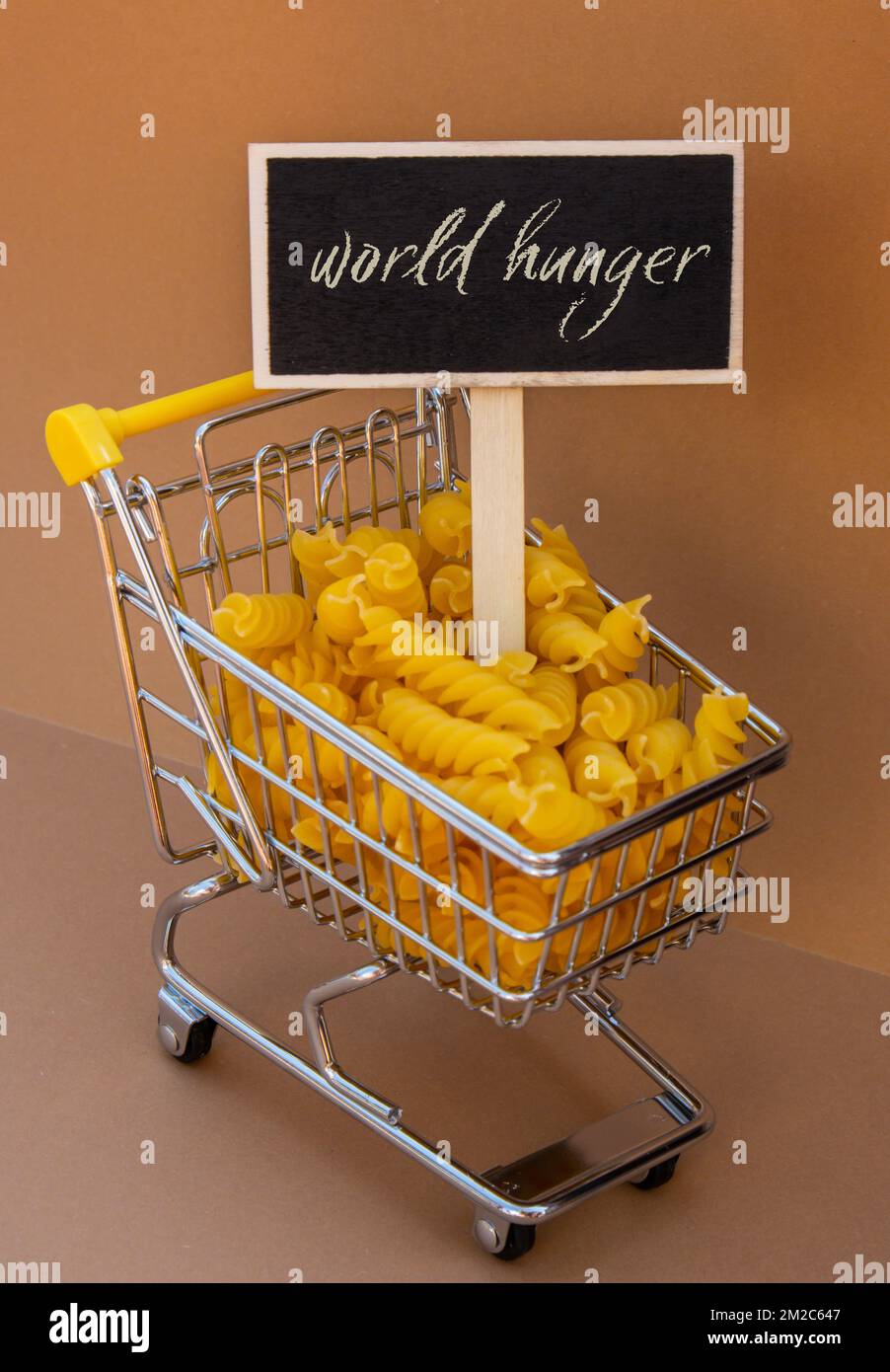 WORLD HUNGER text on Blackboard label against Shopping trolley cart ...