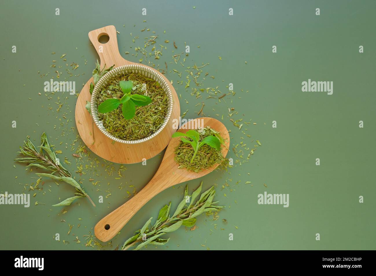 Dried stevia in a round cup and a wooden spoon.Sugar substituteStevia ...