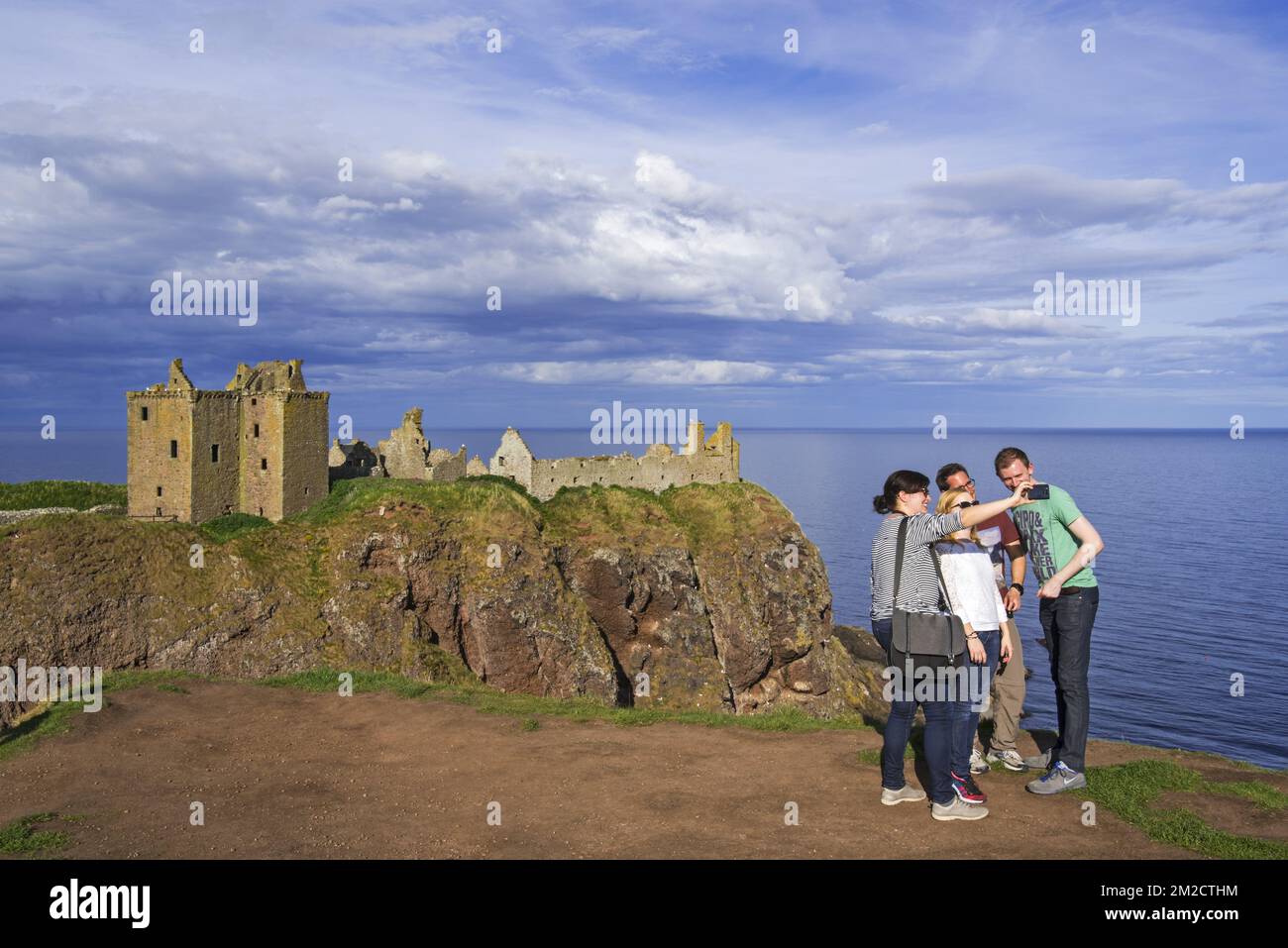 Tourists taking selfies at Dunnottar Castle, ruined medieval fortress ...