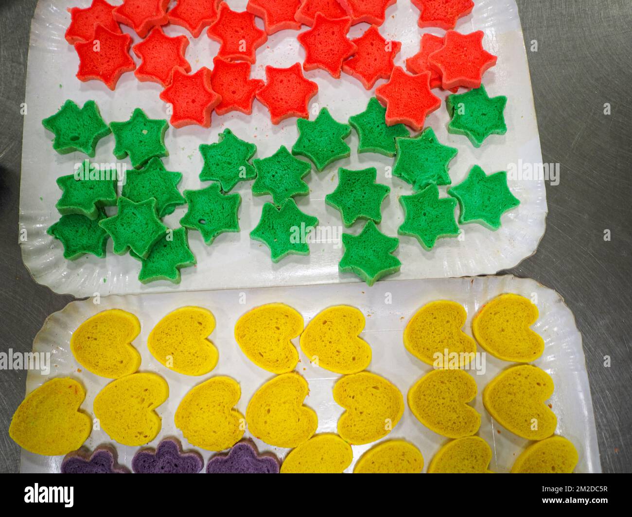 baker chef slicing red violet yellow and green star and heart shaped ...