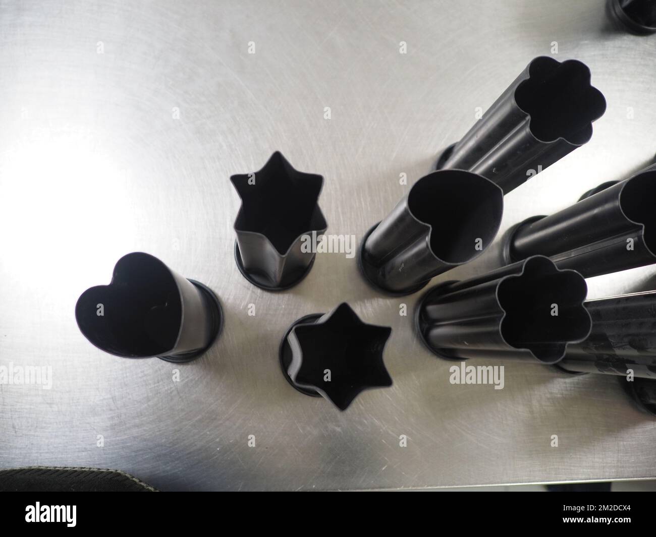 baker filling professional moulds with coloured dough preparing heart ...