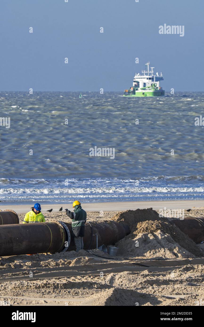 Dredging workers connecting pipes of pipeline during sand replenishment ...