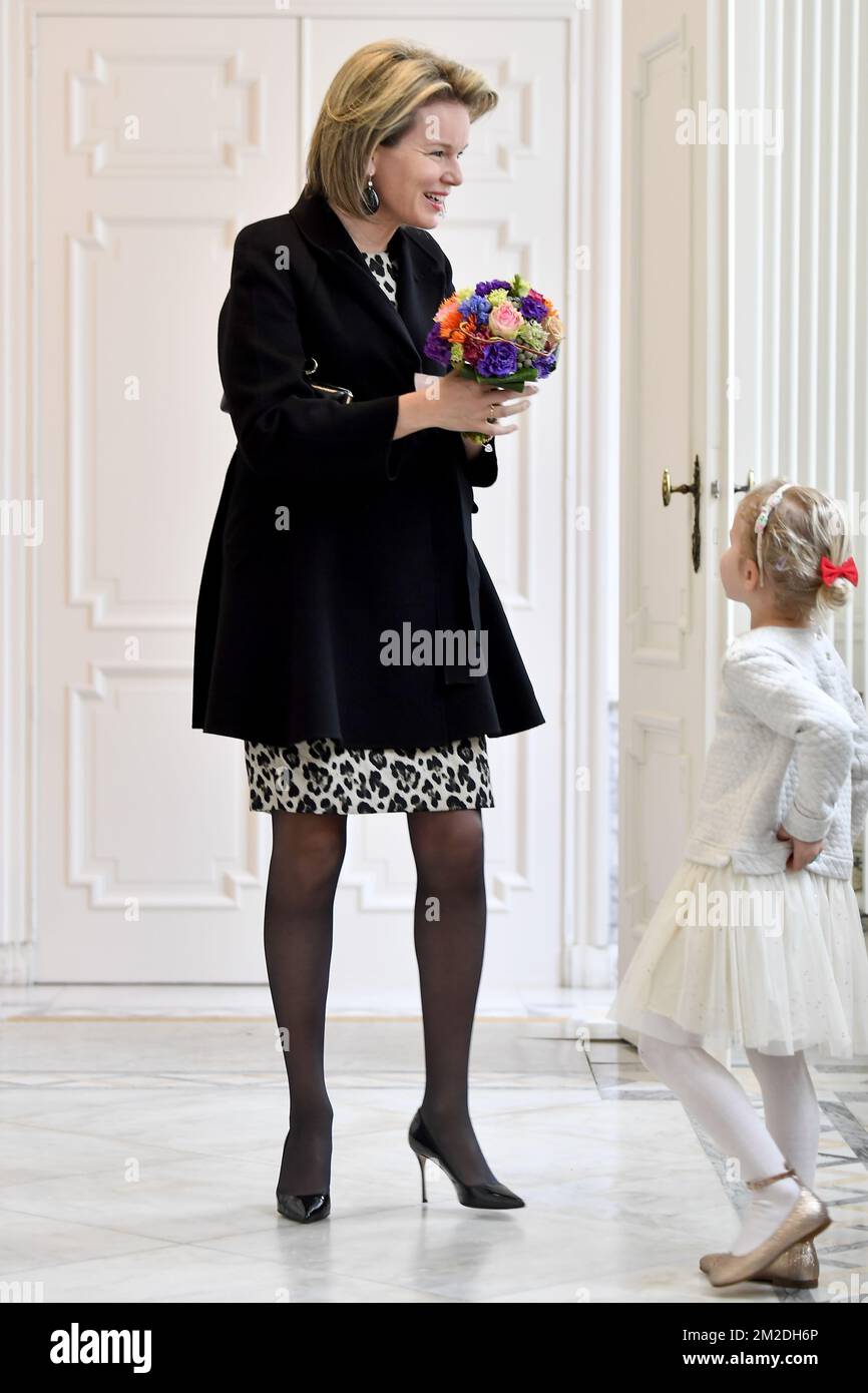 Queen Mathilde of Belgium receives flowers from a child as she arrives ...