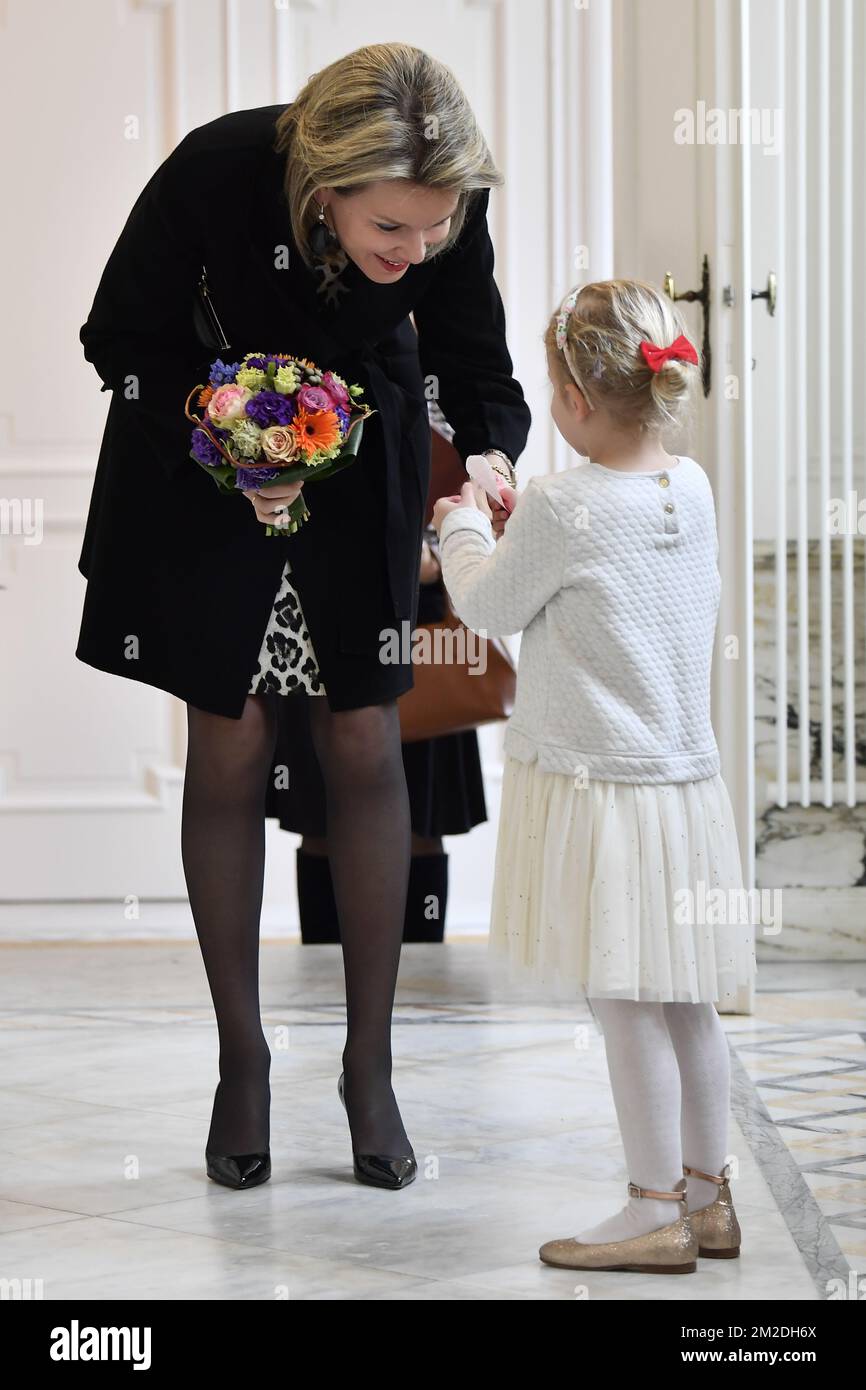 Queen Mathilde of Belgium receives flowers from a child as she arrives ...