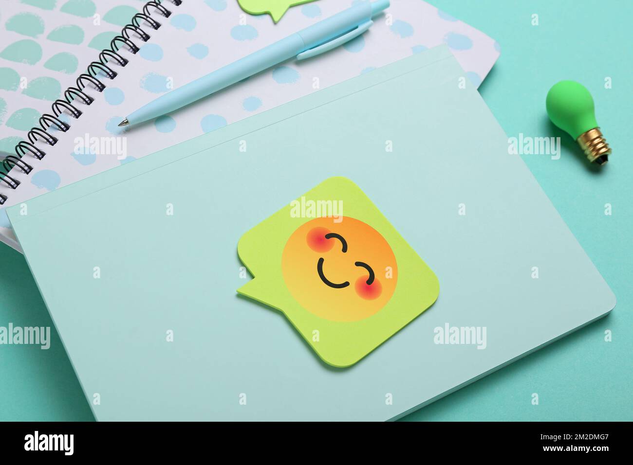 Sticky note with happy emoticon and notebooks on color background Stock ...