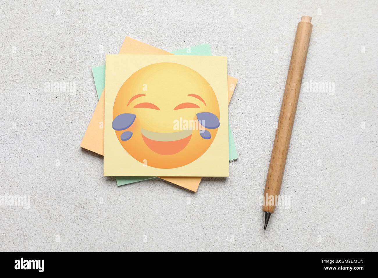 Sticky note with laughing emoticon and pen on light background Stock ...