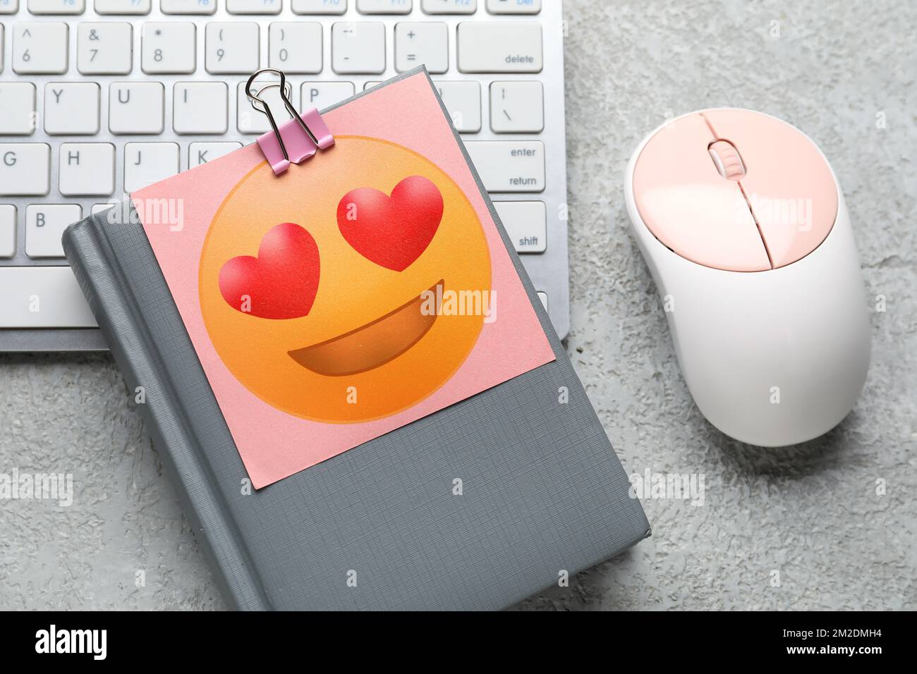 Sticky note with happy emoticon, notebook, computer keyboard and mouse ...