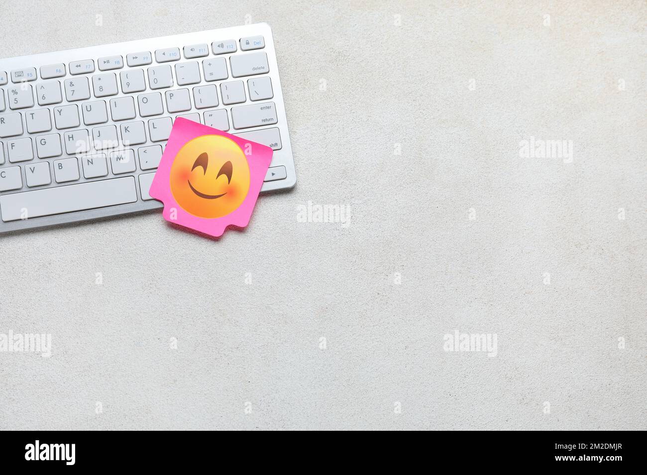 Sticky note with happy emoticon and PC keyboard on light background ...