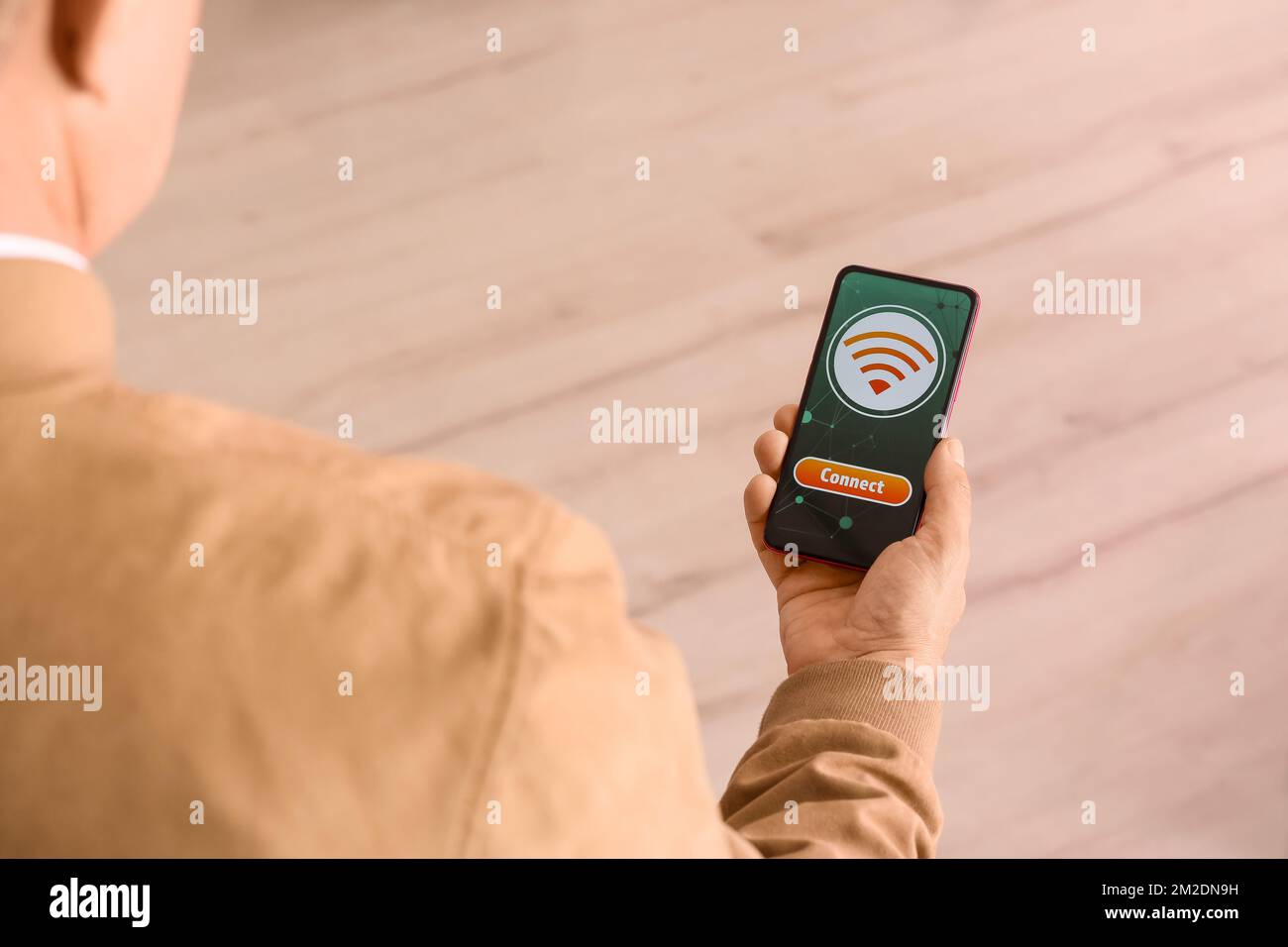 Man holding mobile phone with WiFi symbol and connection button on ...