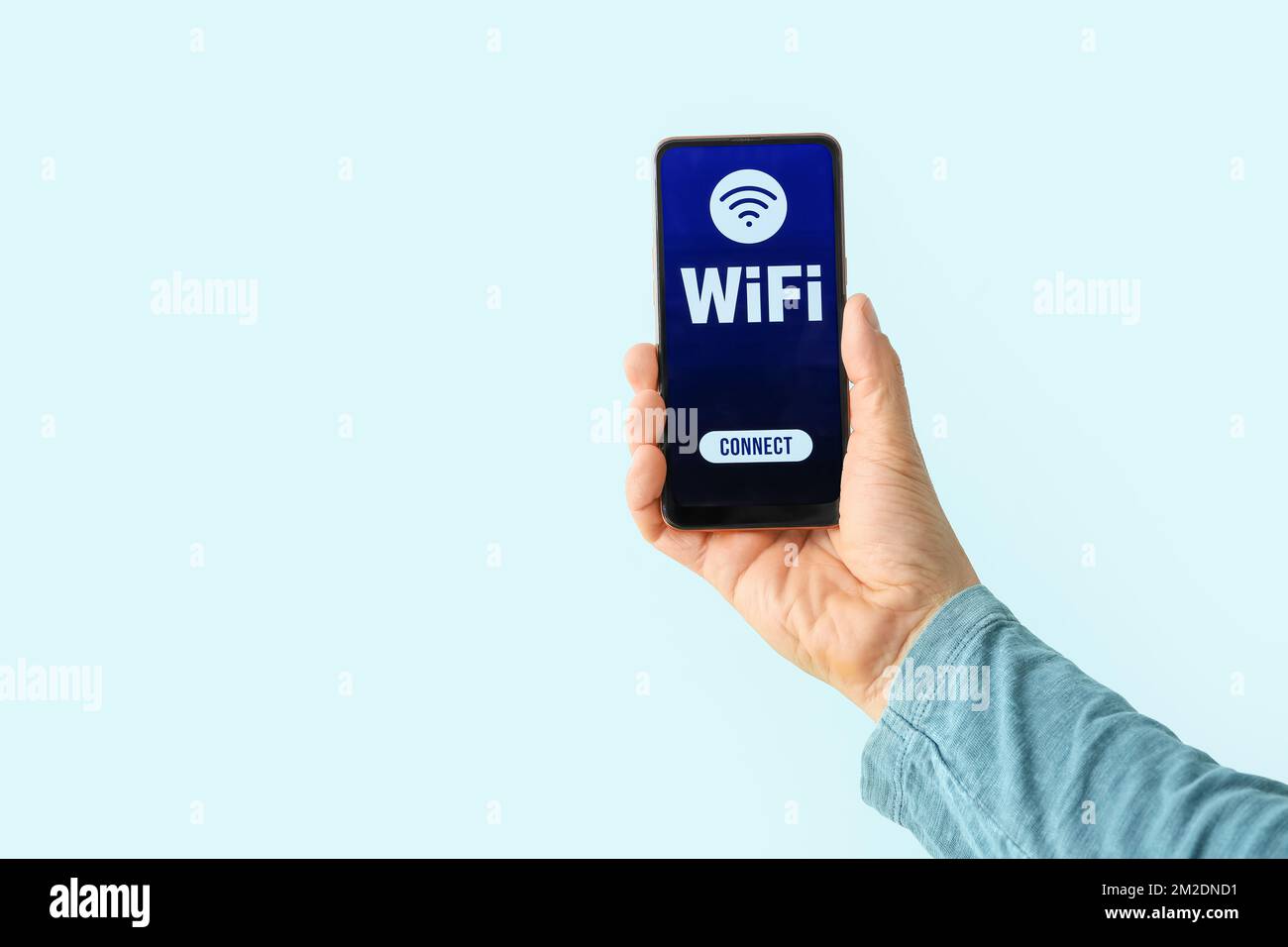 Man holding mobile phone with WiFi symbol and connection button on ...