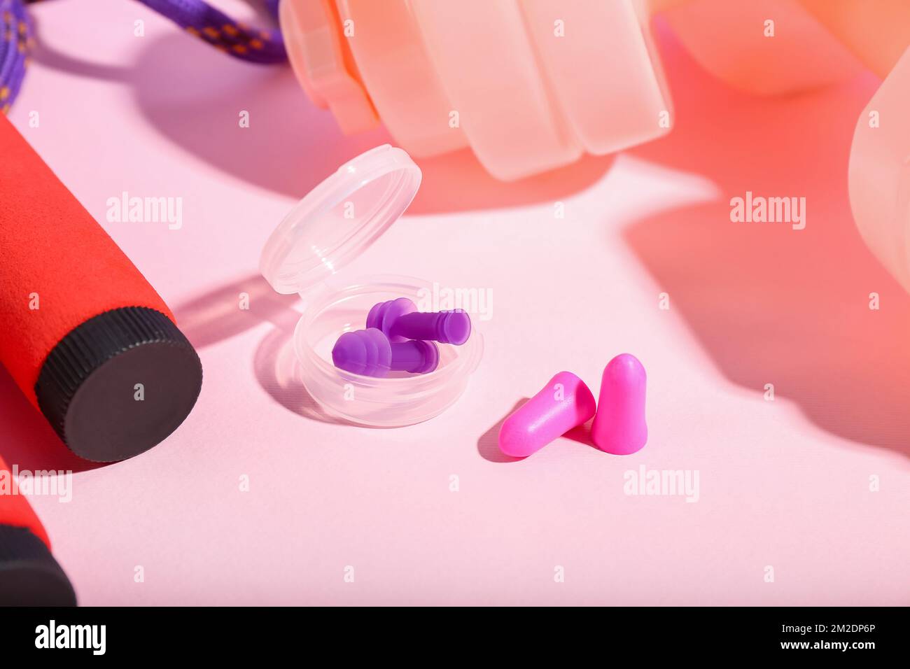 Plastic container with earplugs on pink background Stock Photo - Alamy