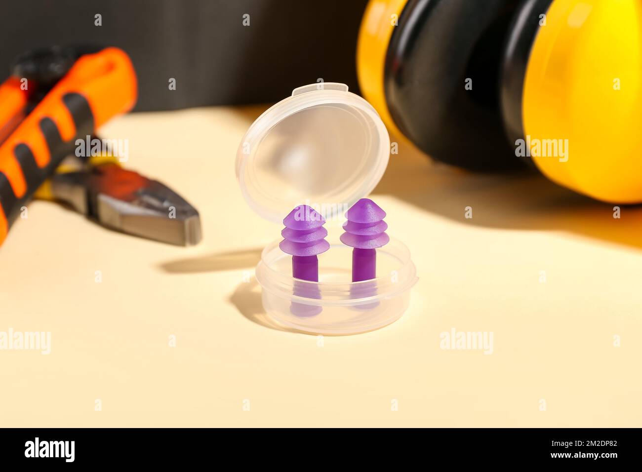 Plastic container with ear plugs on color background Stock Photo - Alamy