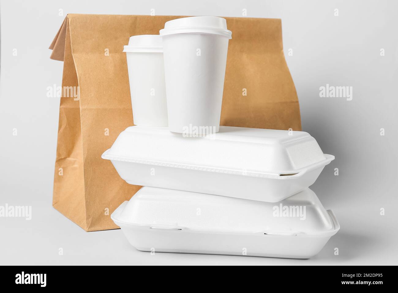 Stack of food containers and paper cups on light background Stock Photo ...