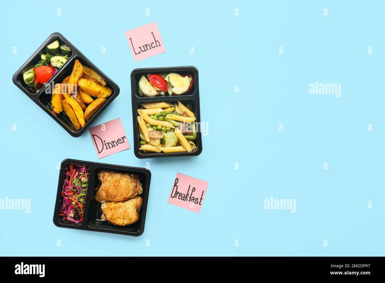 Food containers with meal and sticky notes with words BREAKFAST, LUNCH ...