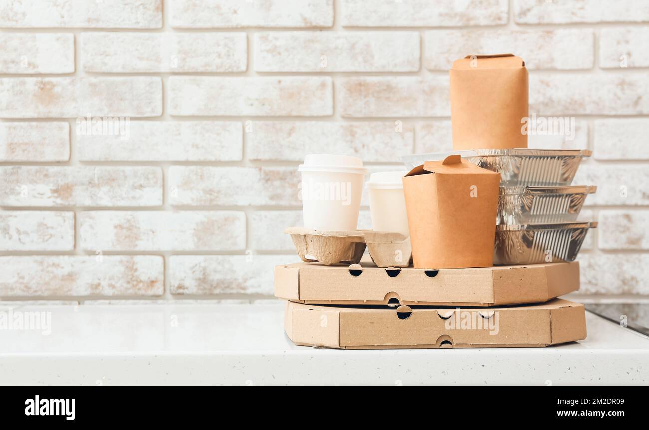 Set of different food delivery containers on white table near light ...