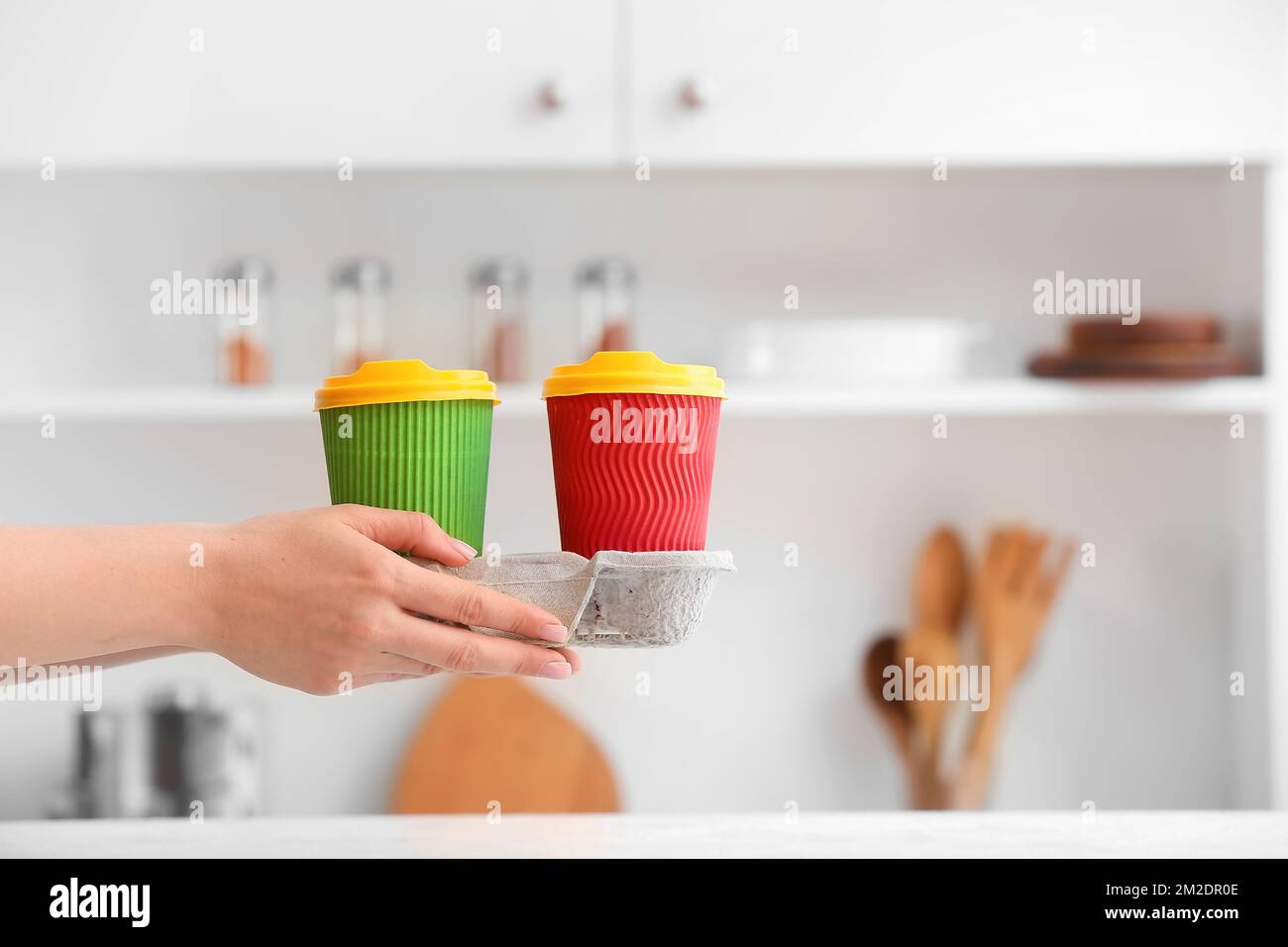 Female hand with paper cup holder on kitchen Stock Photo - Alamy