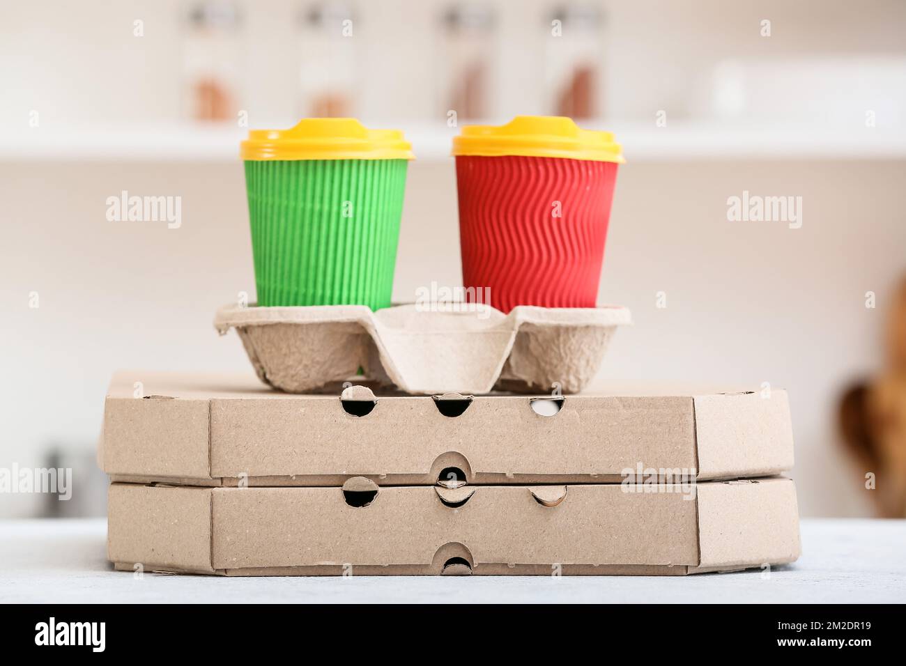 Food delivery boxes and holder with paper cups on white table Stock ...
