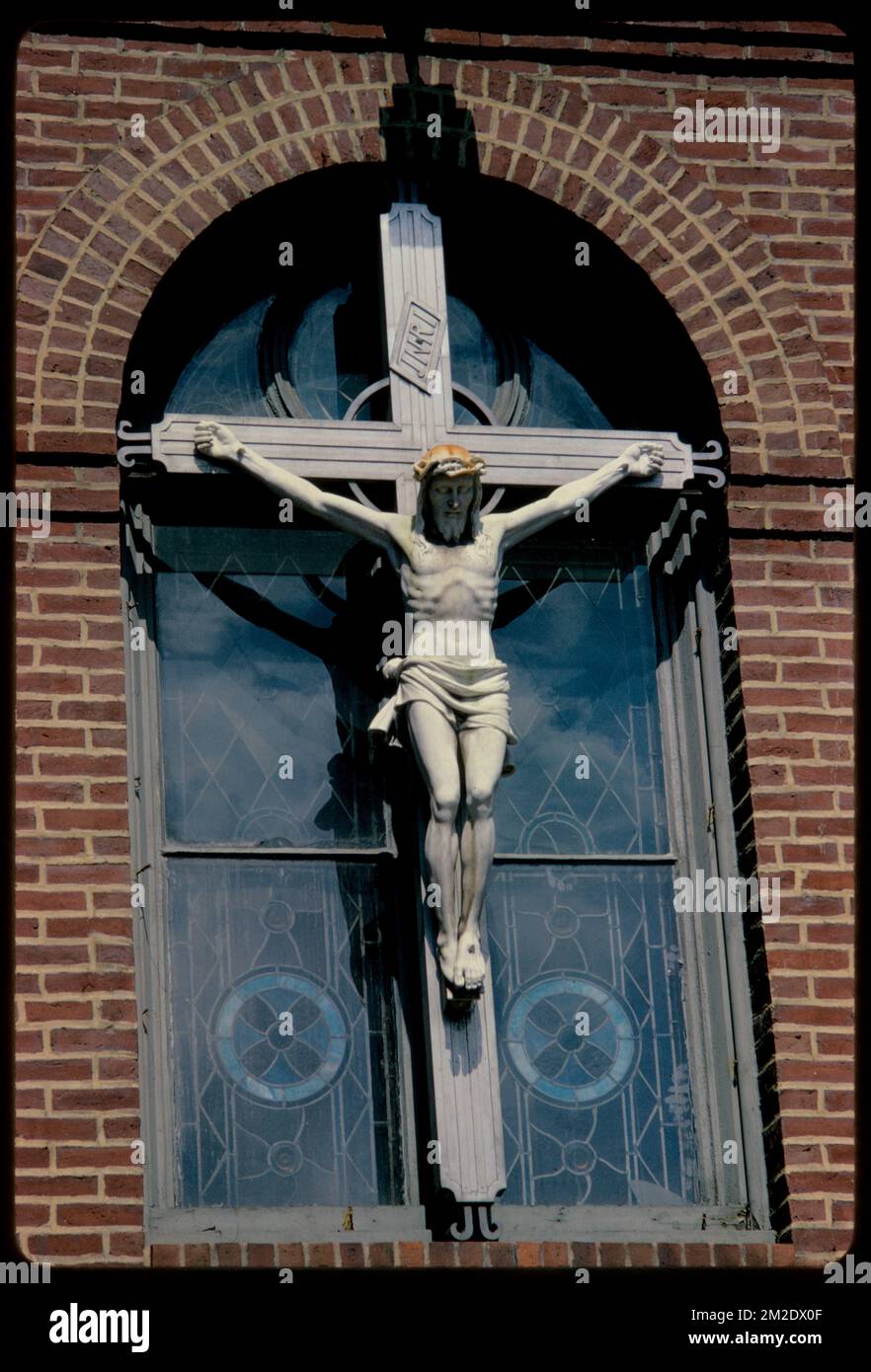 Crucifix on exterior of arched window on brick wall, Boston ...