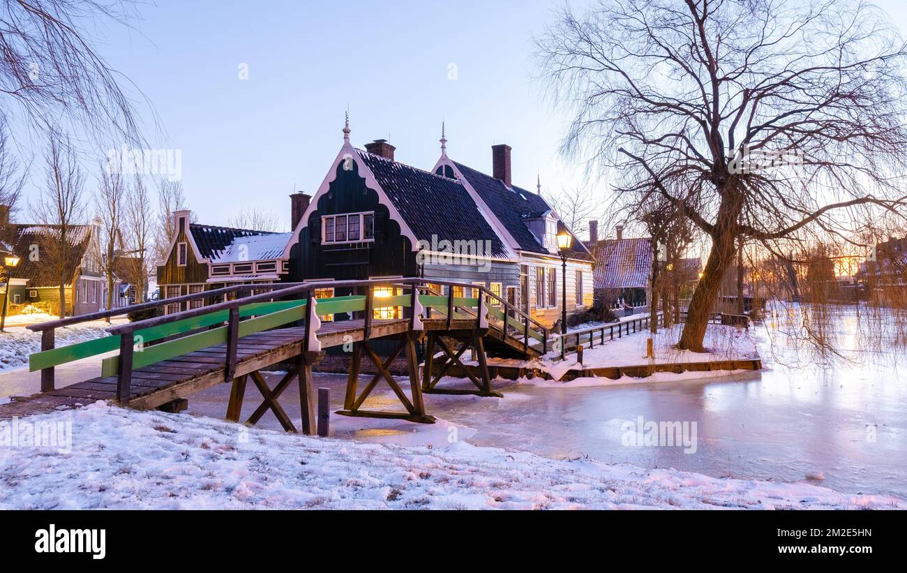 sunrise at the windmill village Zaanse Schans during winter with snow ...