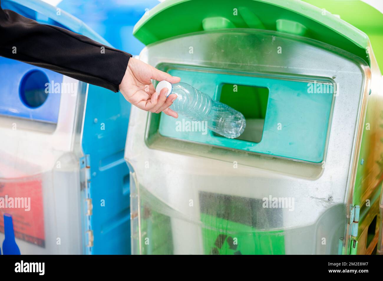 Business woman throwing empty plastic bottle water into recycle garbage ...
