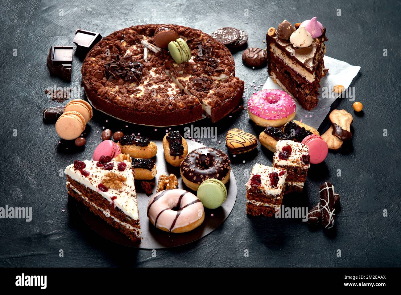 Assortment of confectionery, different types desserts on dark table ...