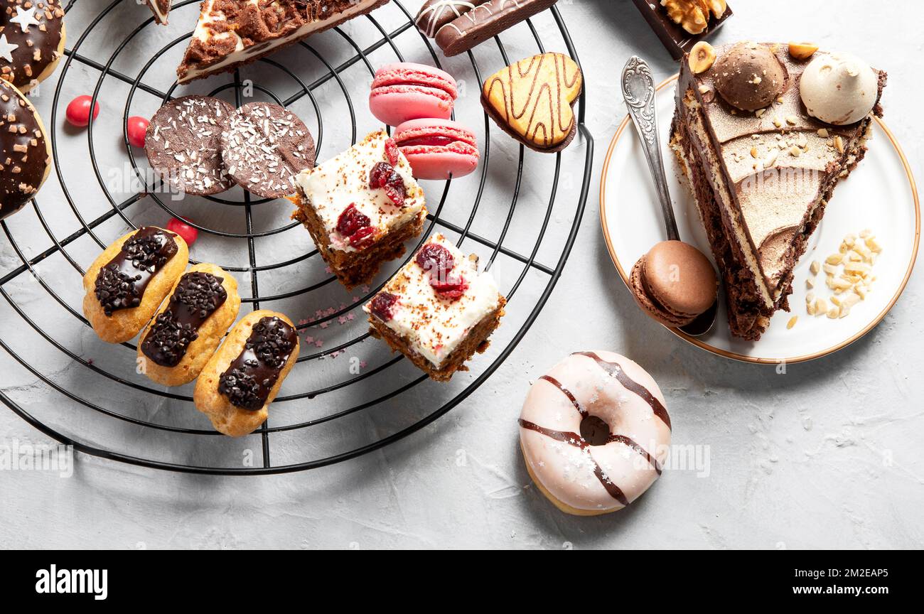 Table with various cookies, donuts, cakes and coffe cups on light ...
