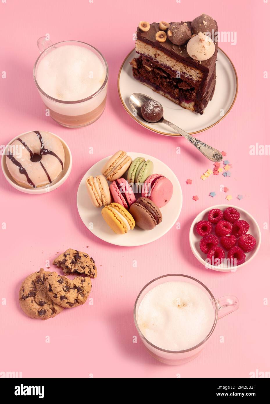 Table with various cookies, donuts, cakes, cheesecakes and coffee cups ...