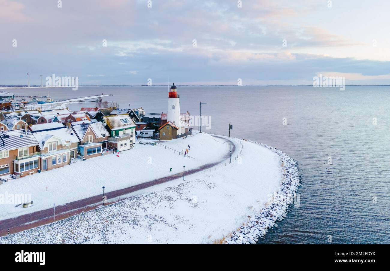 Lighthouse of Urk during winter with snow landscape in the Netherlands ...