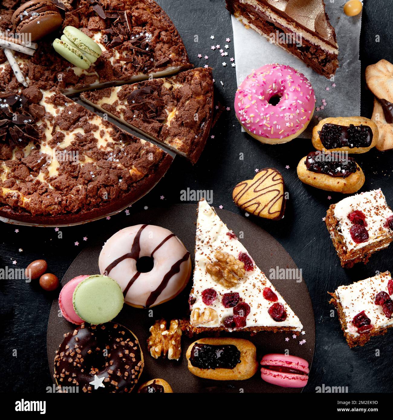 Assortment of confectionery, different types desserts on dark table ...