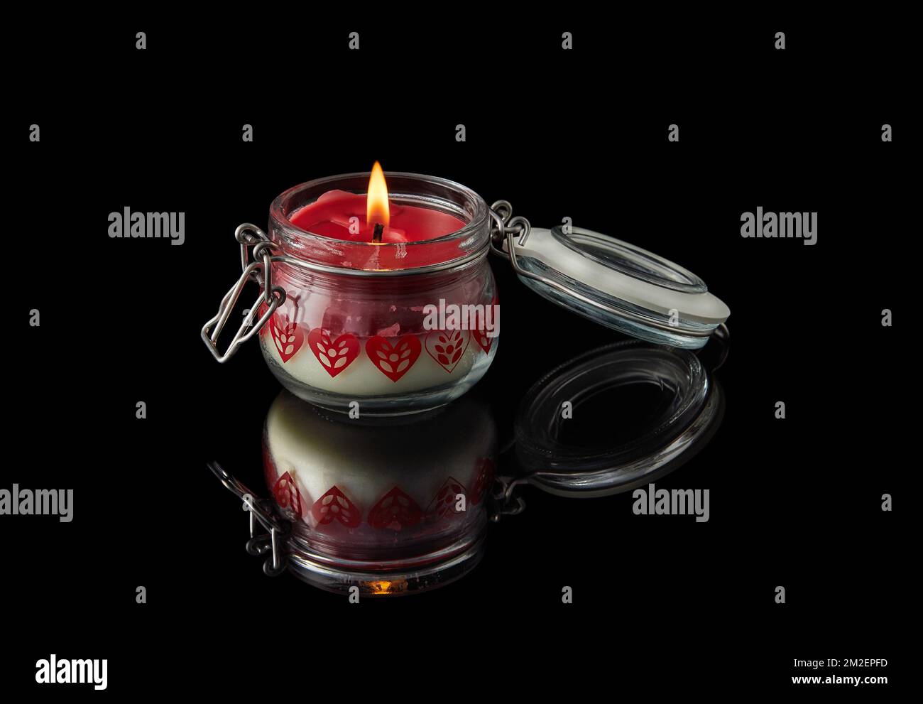 Lit candle on black background with aromas of vanilla, cherry ...
