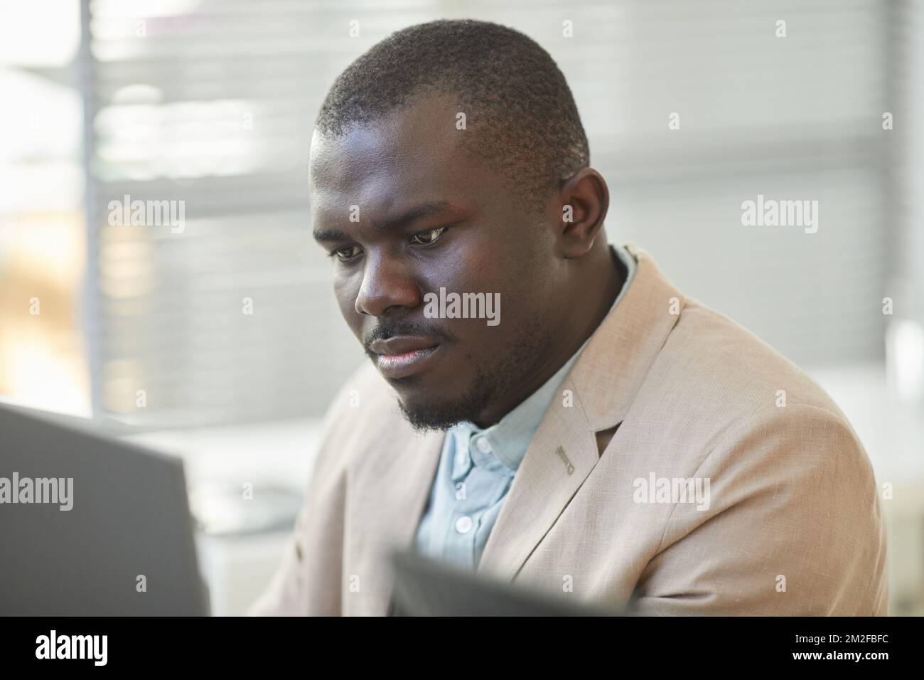 Close up of black man looking at computer screen while working in ...
