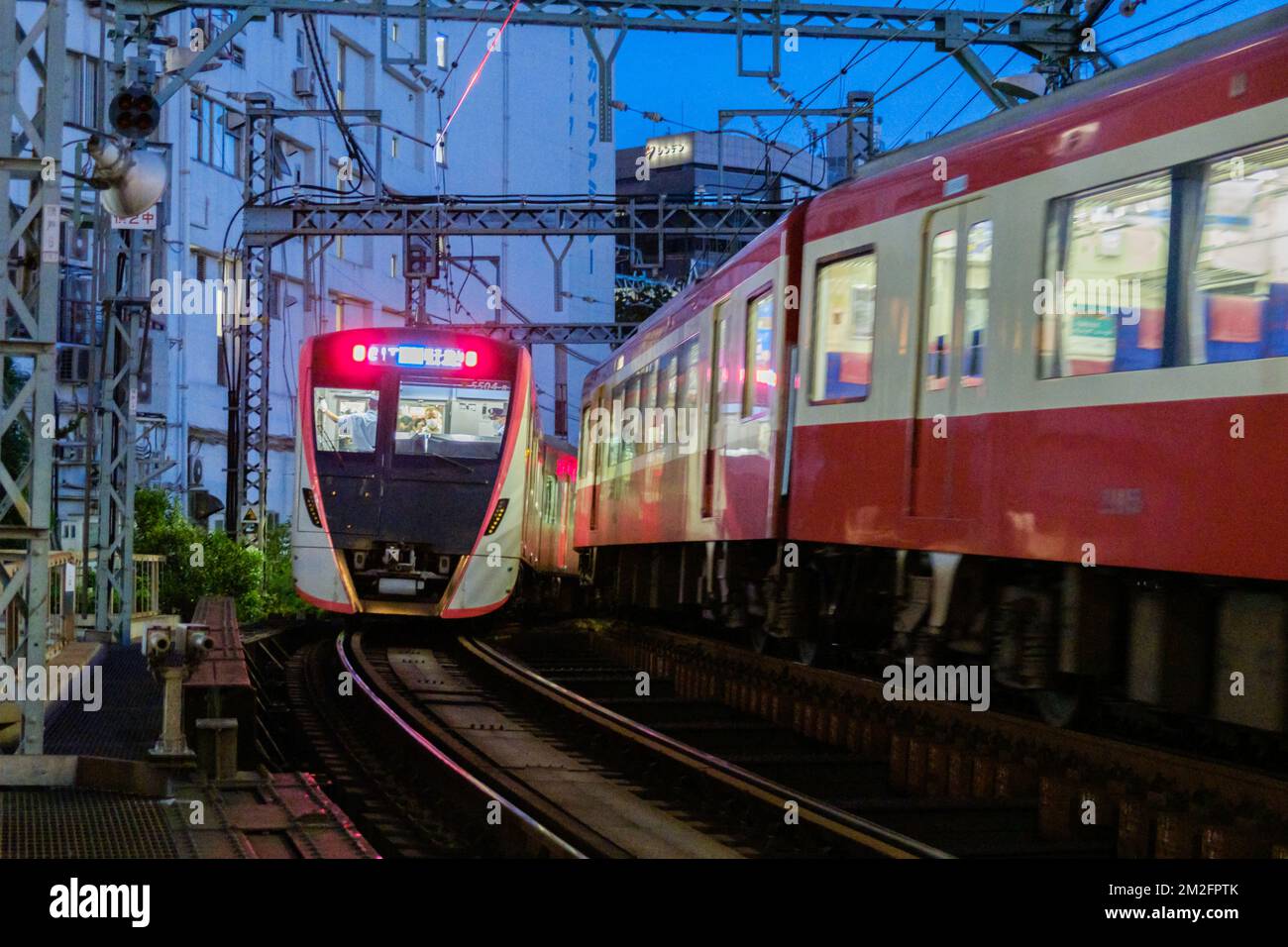 The train on the right is a Keikyu Line commuter train arriving at Yokohama Station from the ...
