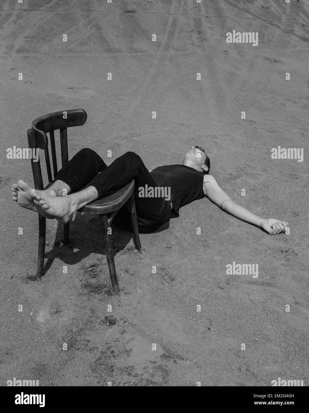 Lone Man lying on chair in desert Stock Photo - Alamy