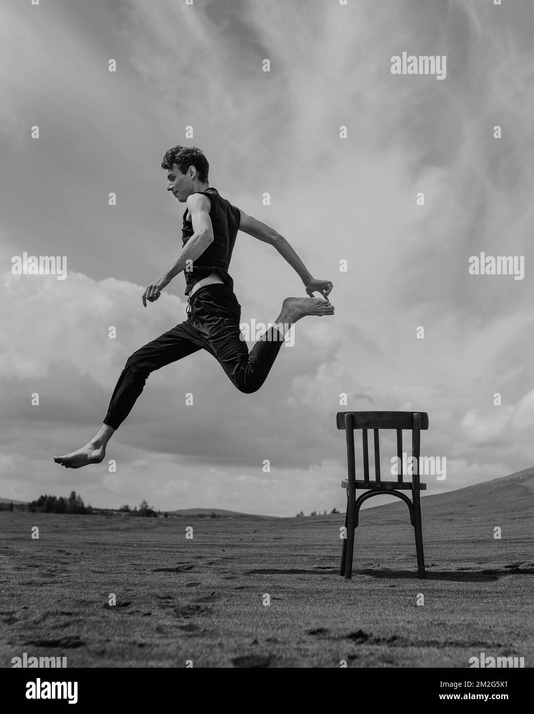Man jumping over chair in desert Stock Photo - Alamy
