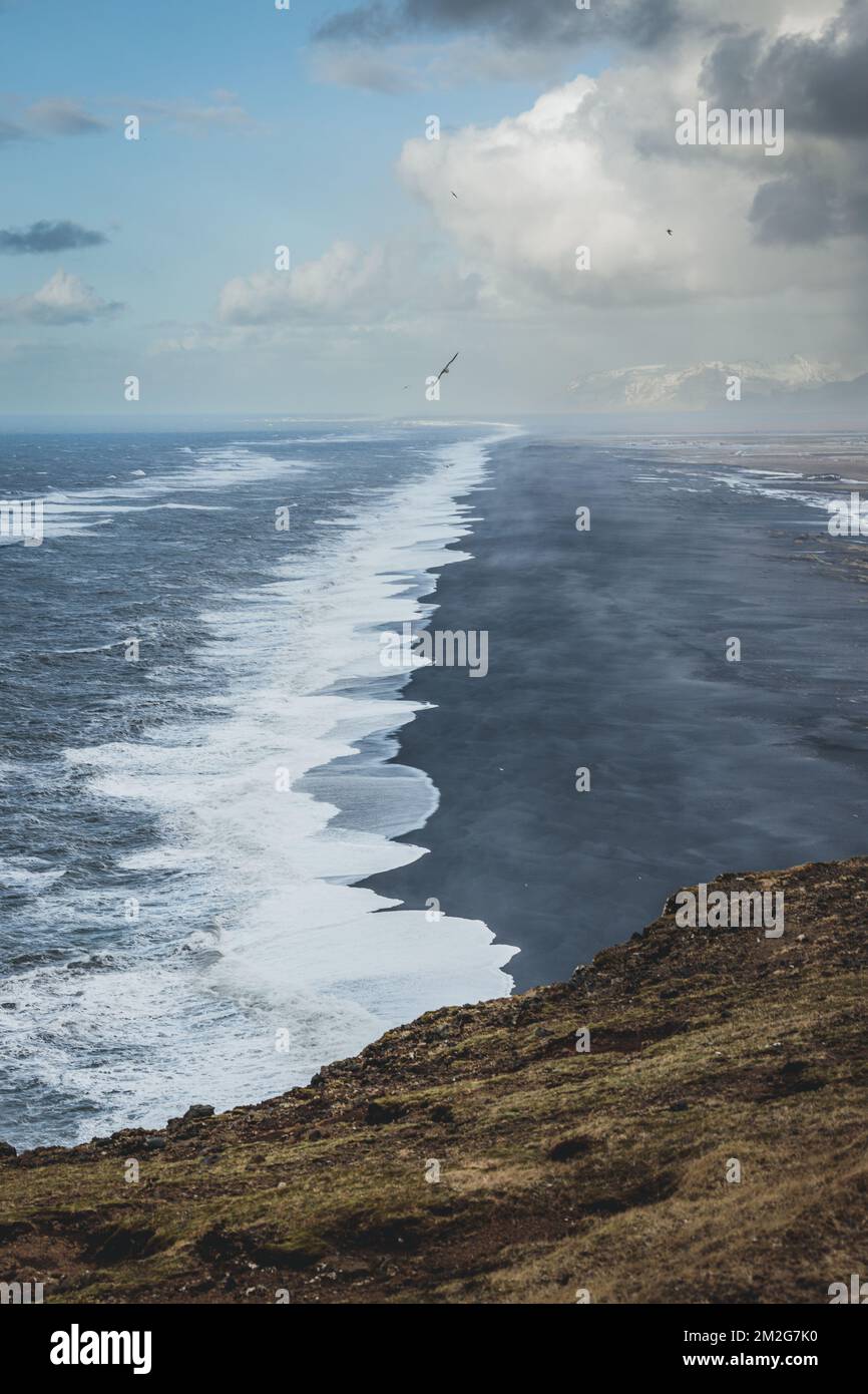 The vertical view of sea waves touching the volcanic coastline on a ...