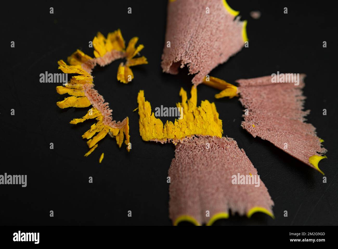 Waste from Sharpening a yellow colored crayon on black background, soft ...
