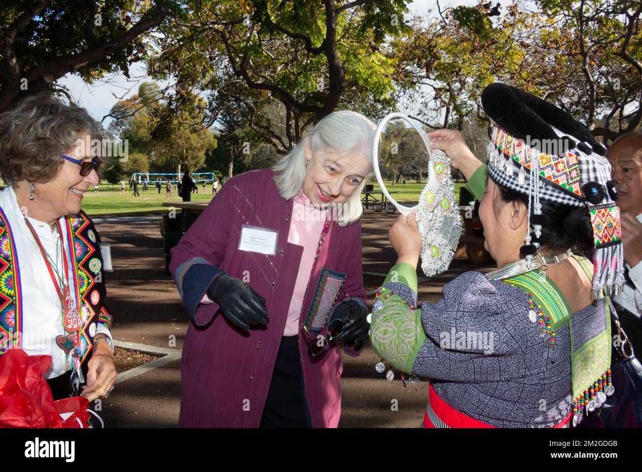 White female historian receives a silver necklace from Hmong female ...
