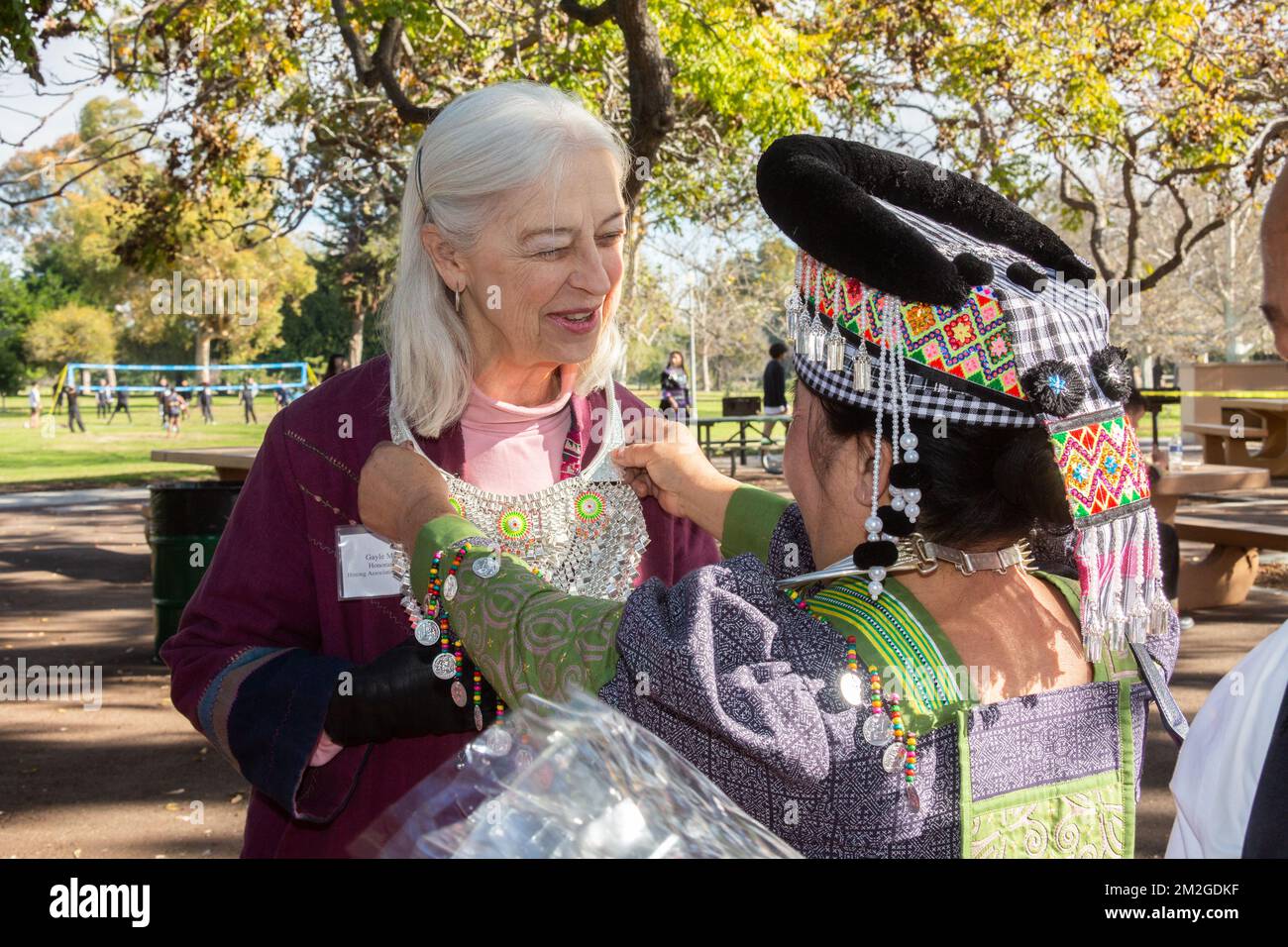 White female historian receives a silver necklace from Hmong female ...