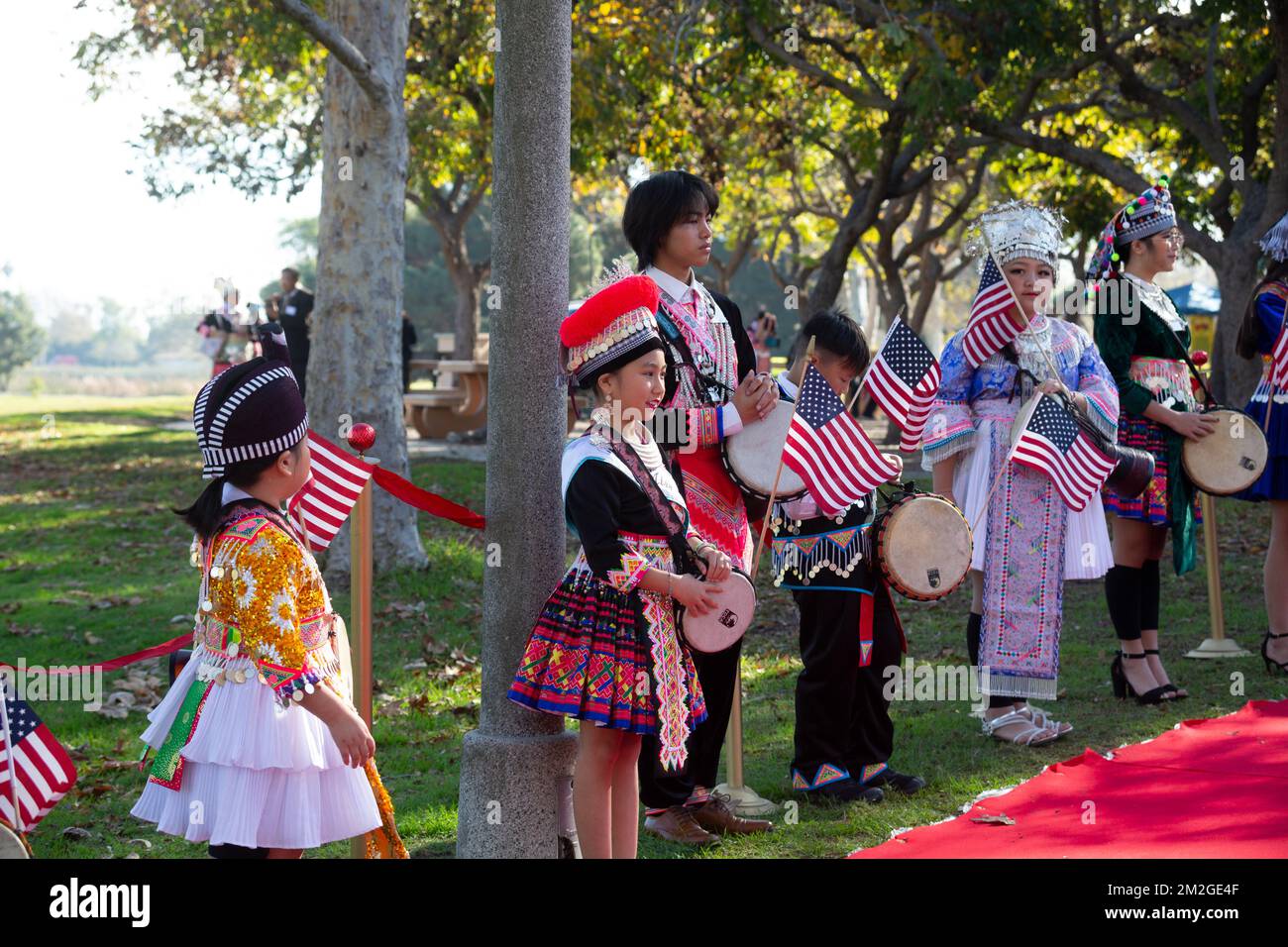 Children and teens in traditional attire with drums and American flags ...
