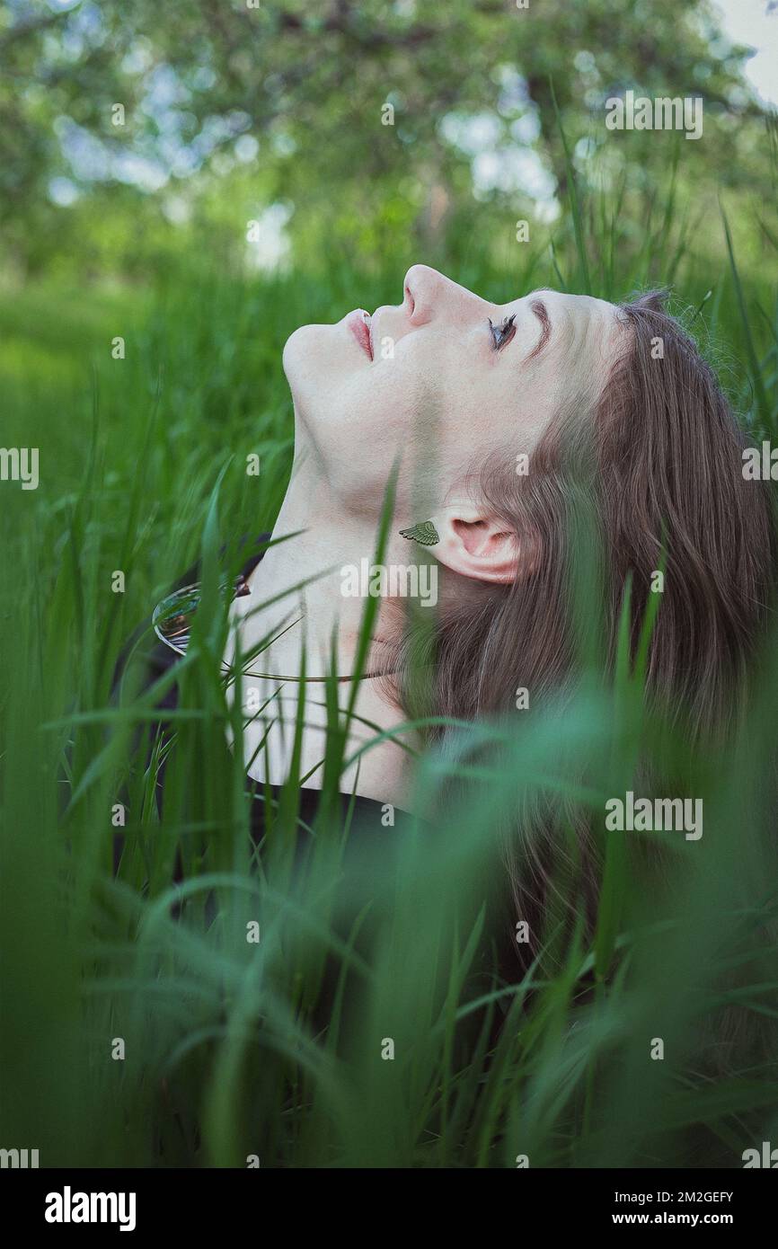 Close up woman in tall grass looking up at sky portrait picture Stock ...
