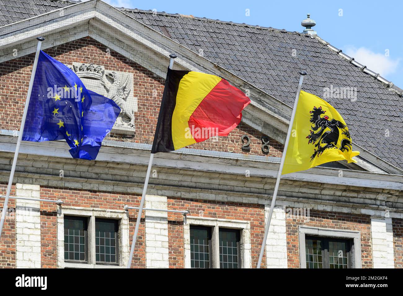 Three flags on a town hall facade - European flag - Belgian flag ...